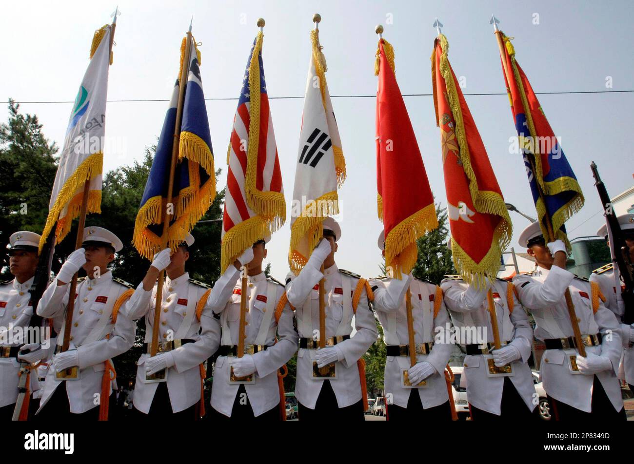 South Korean marine honor guards hold flags during a ceremony to ...