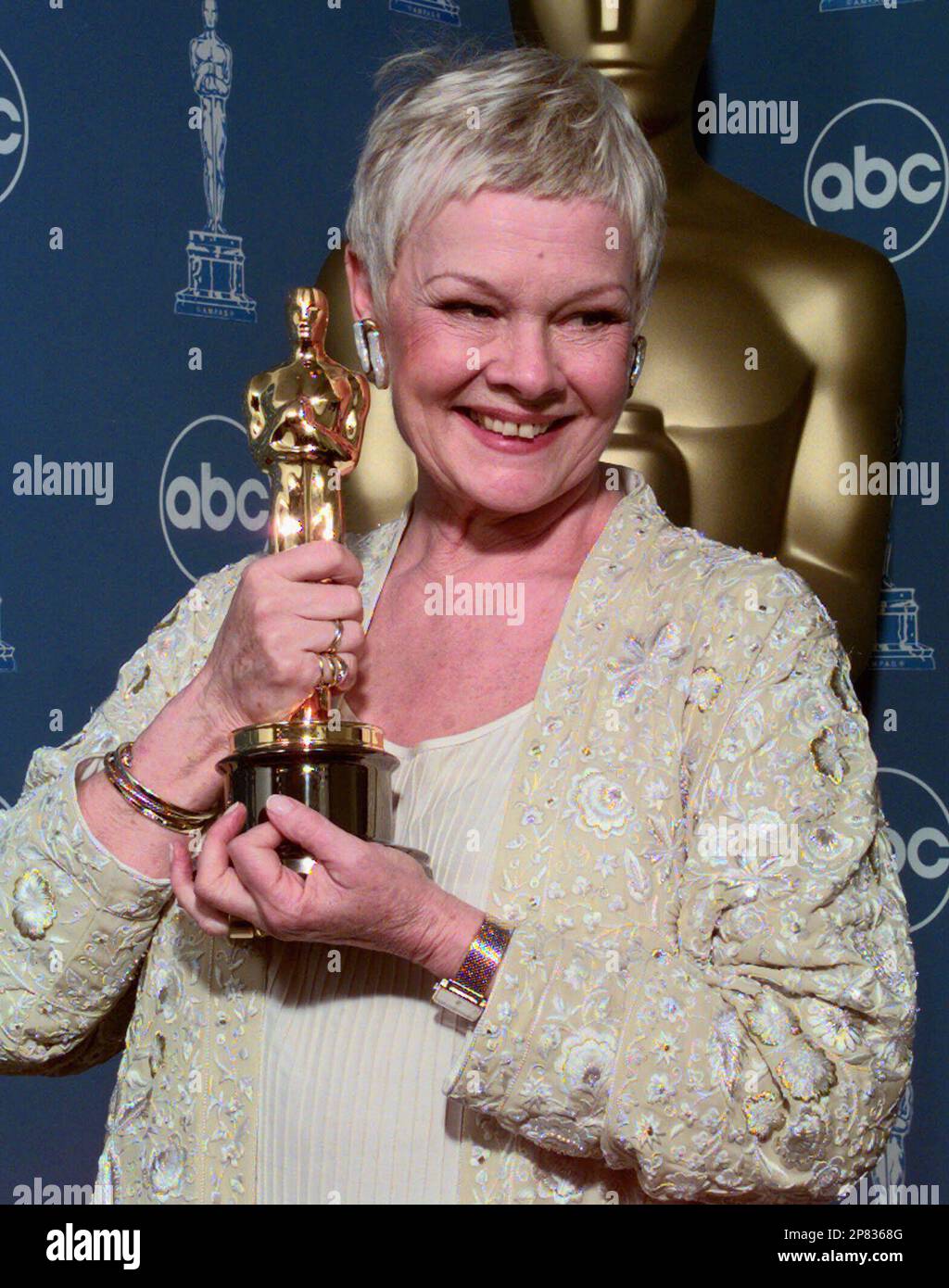 This is a Sunday, March 21, 1999, file photo of Judi Dench holding her ...