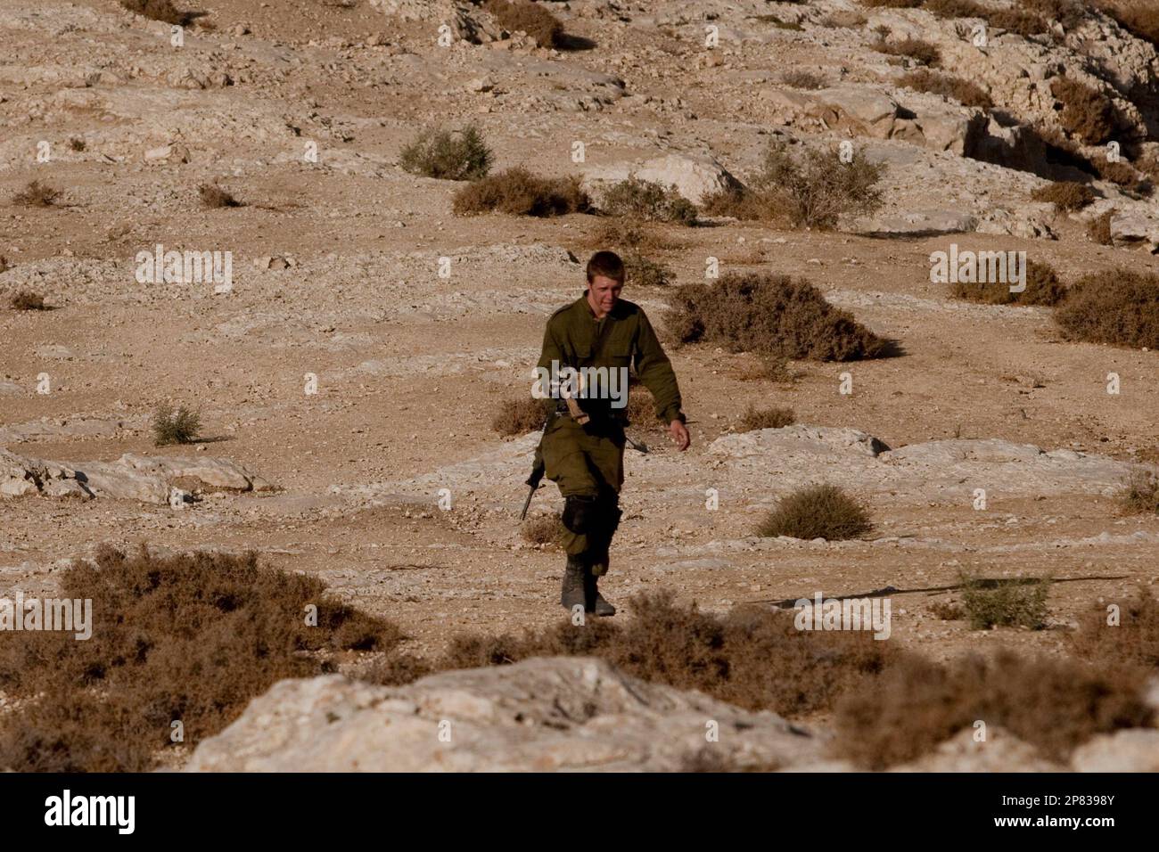 An Israeli soldier carries an object as he performs searches at the ...