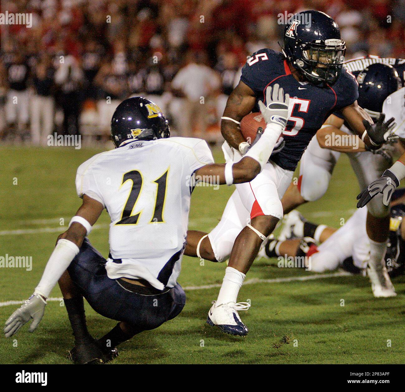 Arizona's Nic Grigsby (5) runs pass Northern Arizona's Daivon Dumas (21 ...