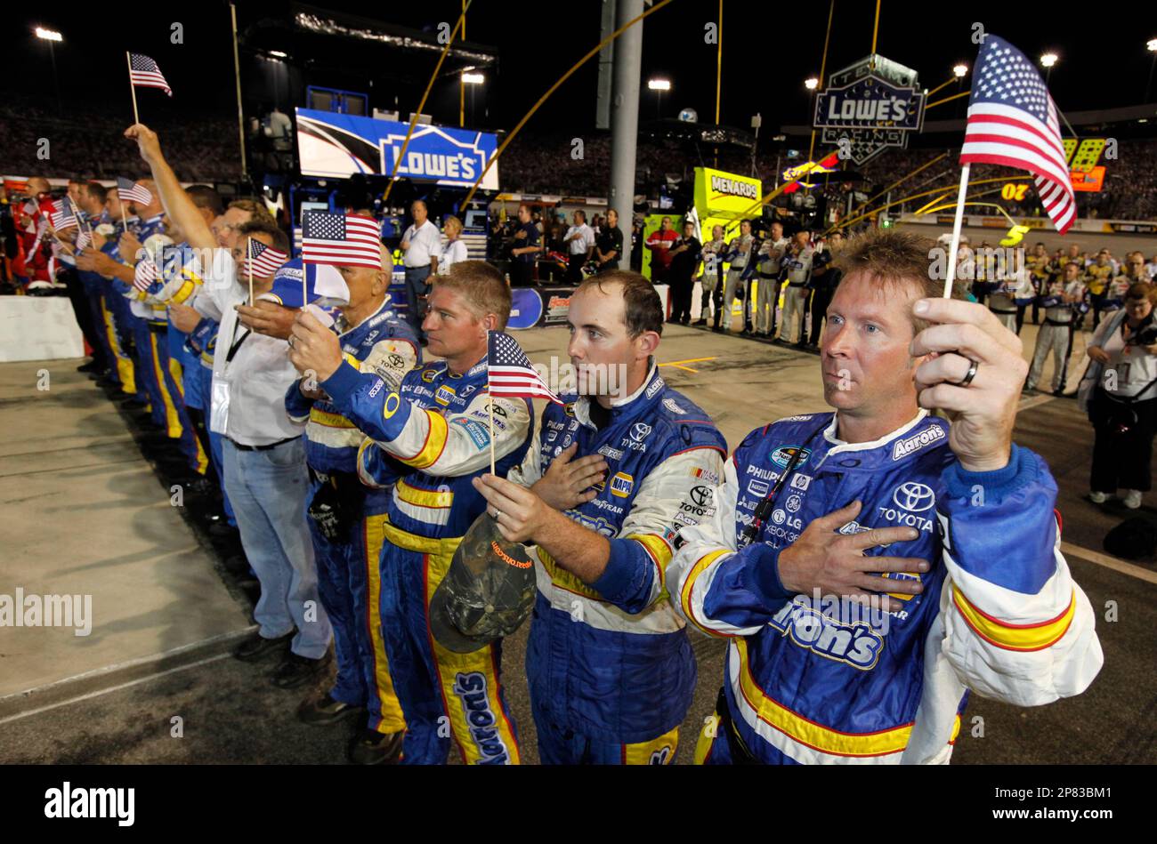 The pit crew for David Reutimann holds U.S. flags during the national ...
