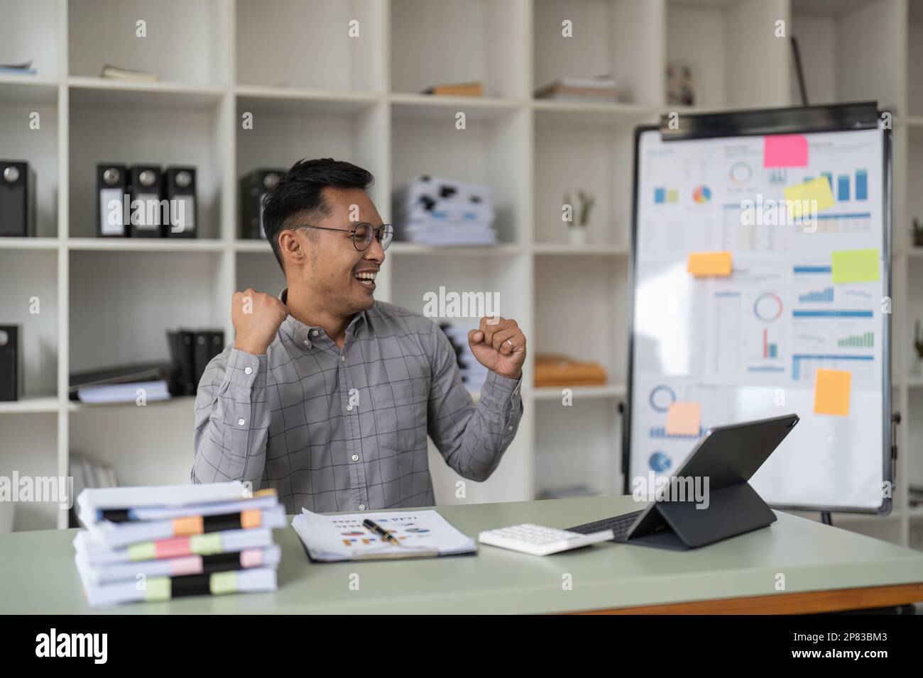 Construction engineer with blueprint making high five while standing on ...