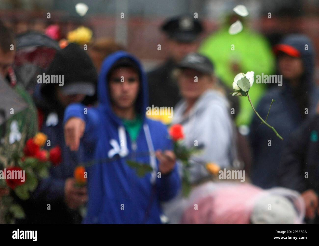 Mourners throw flowers into the ground zero reflecting pool during the ...