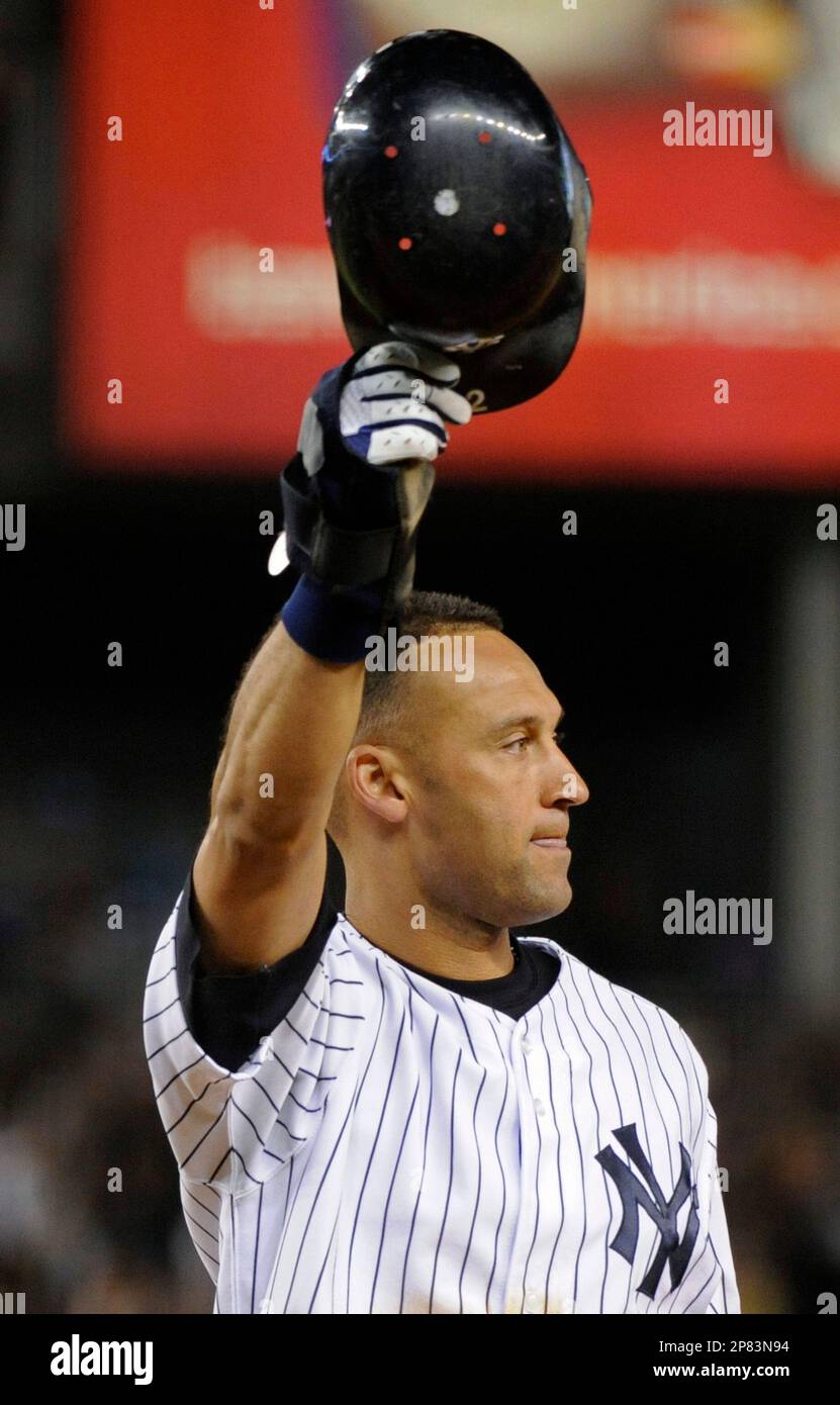 New York Yankees' Derek Jeter tips his cap after hitting a single ...