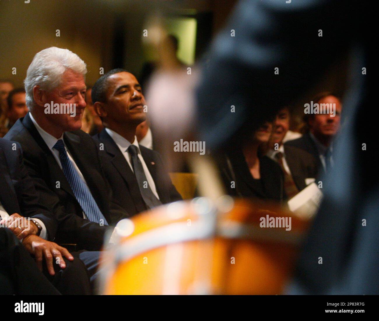 President Barack Obama and former President Bill Clinton listen as ...