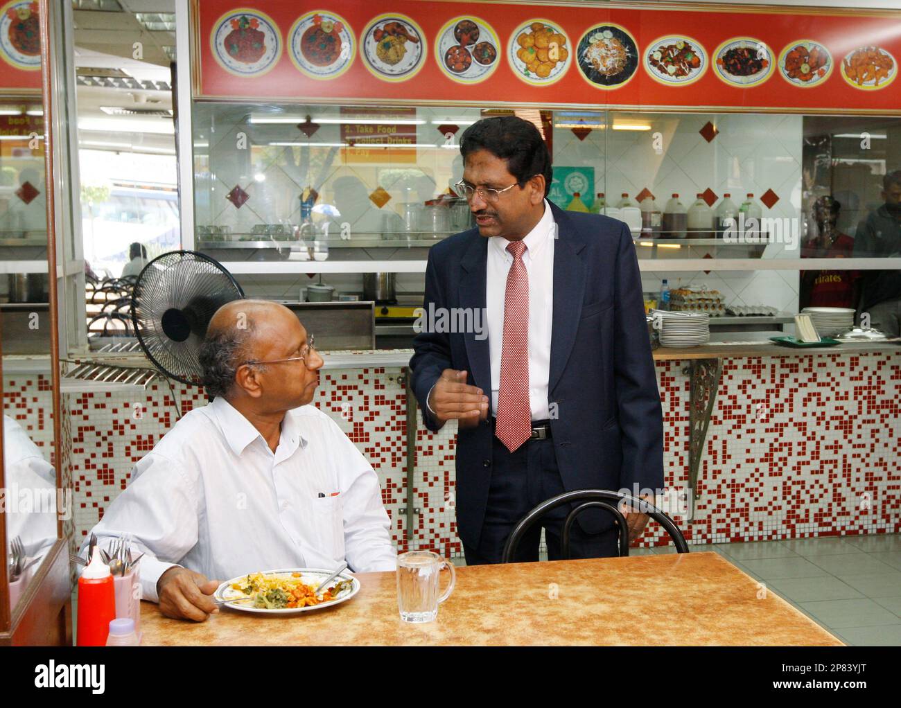 McCurry restaurant owner A.M.S.P. Suppiah, right, talks to a customer ...