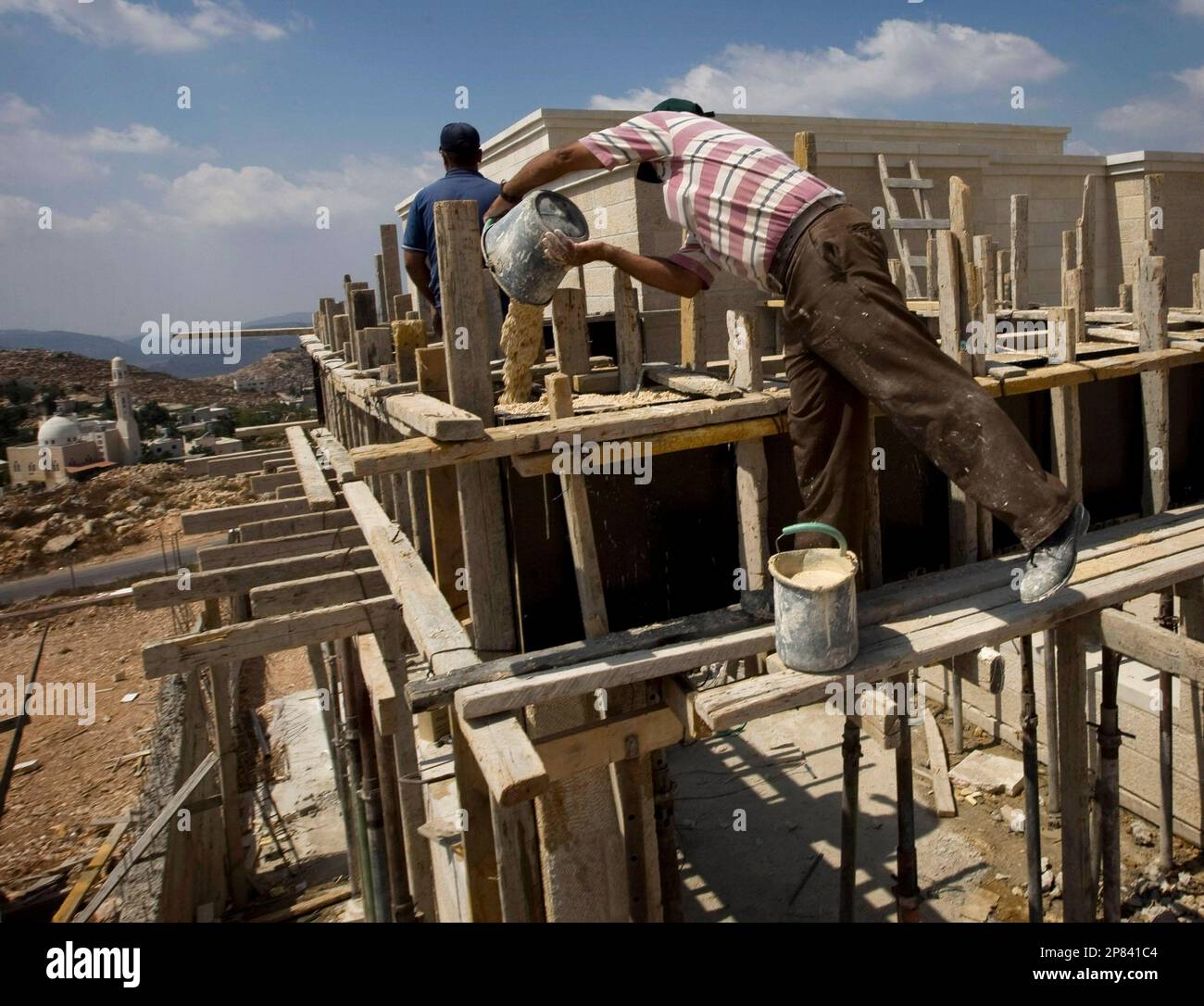 Palestinian construction workers build a new house in the Jewish West ...