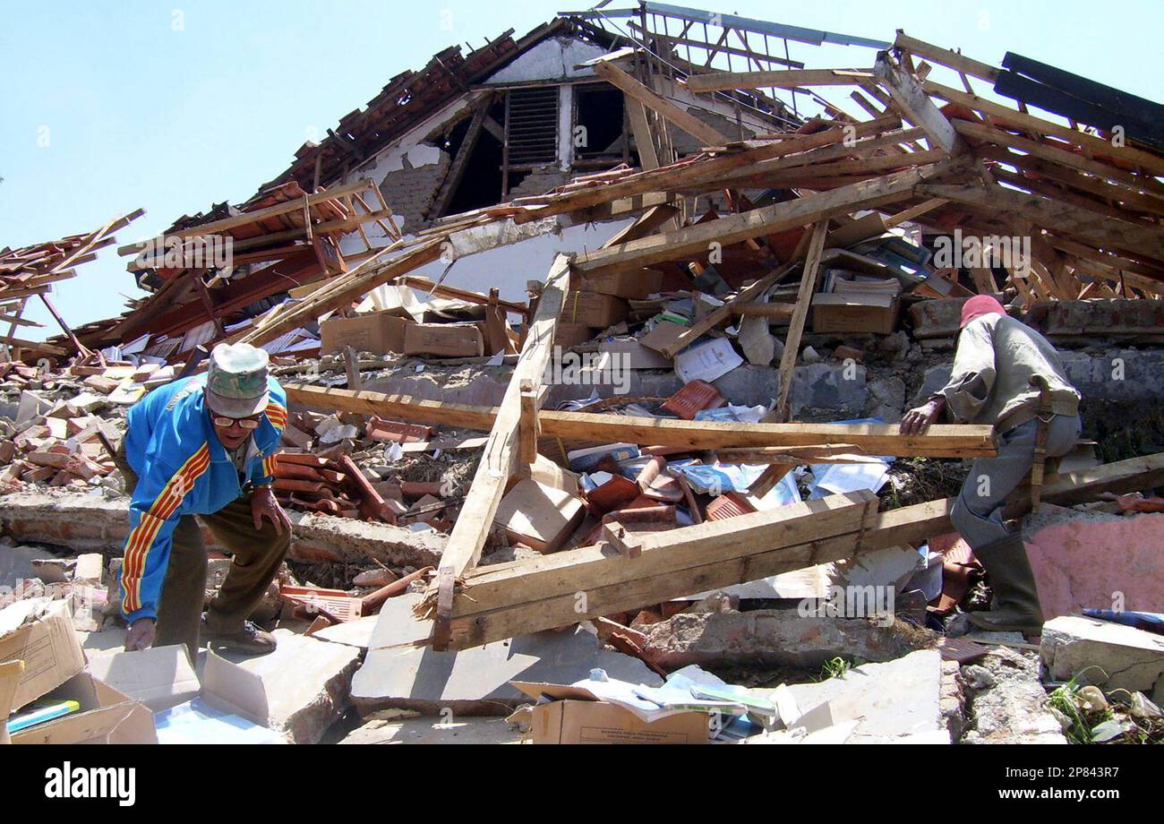 Indonesian men clear rubbles from a school building destroyed by an ...