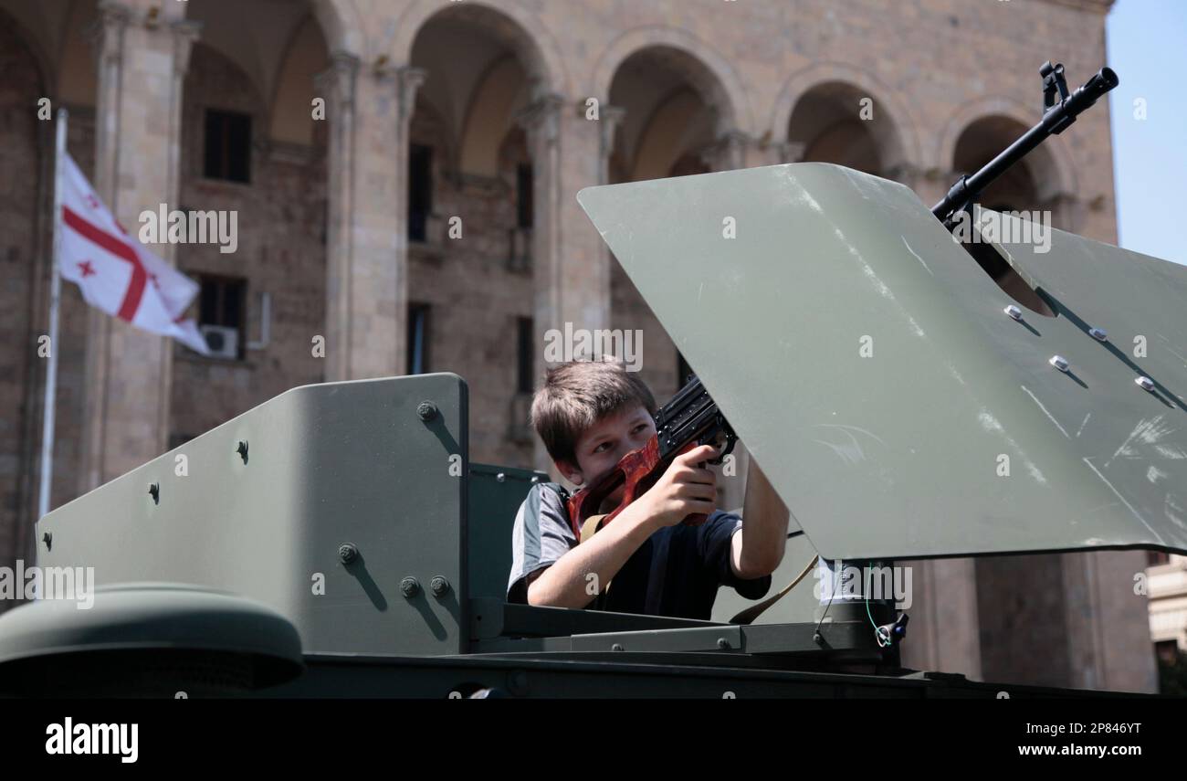 A Georgian boy takes aim with a machine gun during a military show in ...