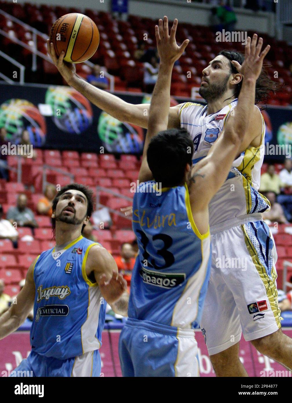 Argentina's Luis Scola, right, drives for a lay up as Uruguay's Juan ...