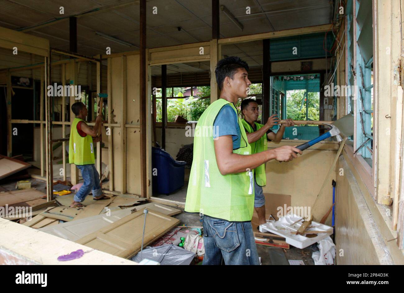 A demolition team pulls down a houses in Buah Pala village on Penang ...