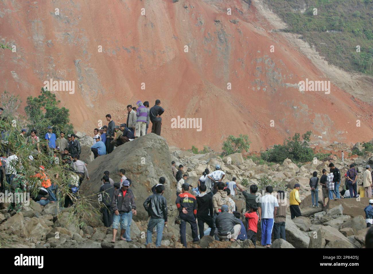 Villagers look at the site where an earthquake-triggered landslide hit ...