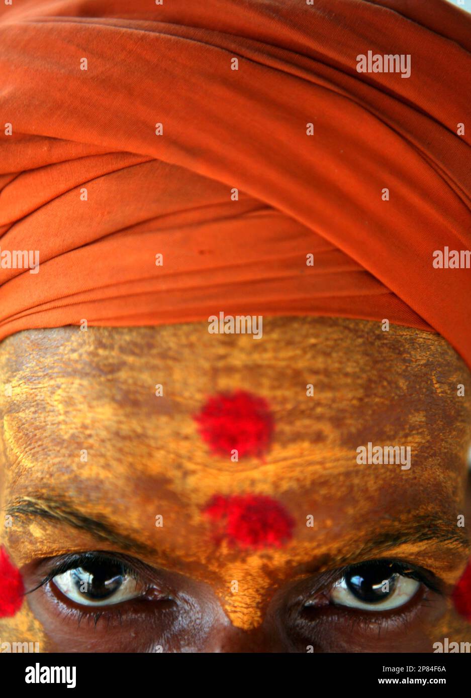A Sadhu, or Hindu holy man, face smeared with vermillion and colored ...