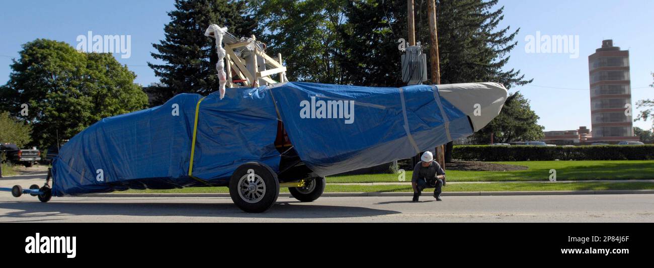 A worker looks at the Spirit of Carnauba airplane is it is taken by ...