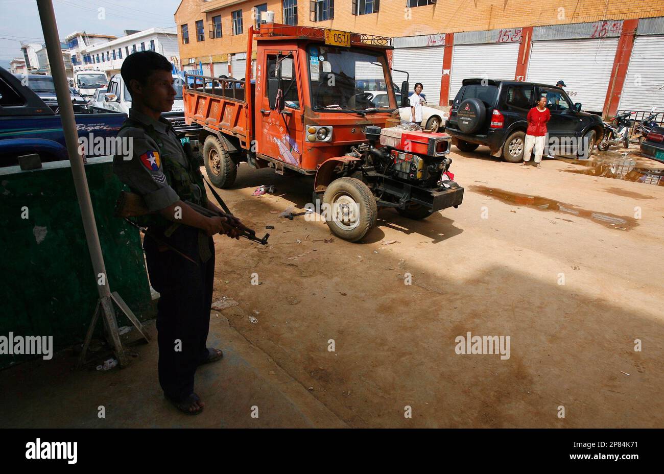 A Myanmar border guard stands on duty on a street of Kokang, Myanmar ...