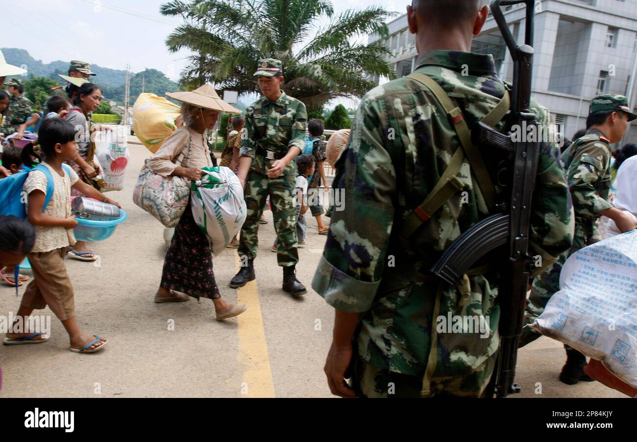 Myanmar refugees walk past Chinese paramilitary police to return to ...