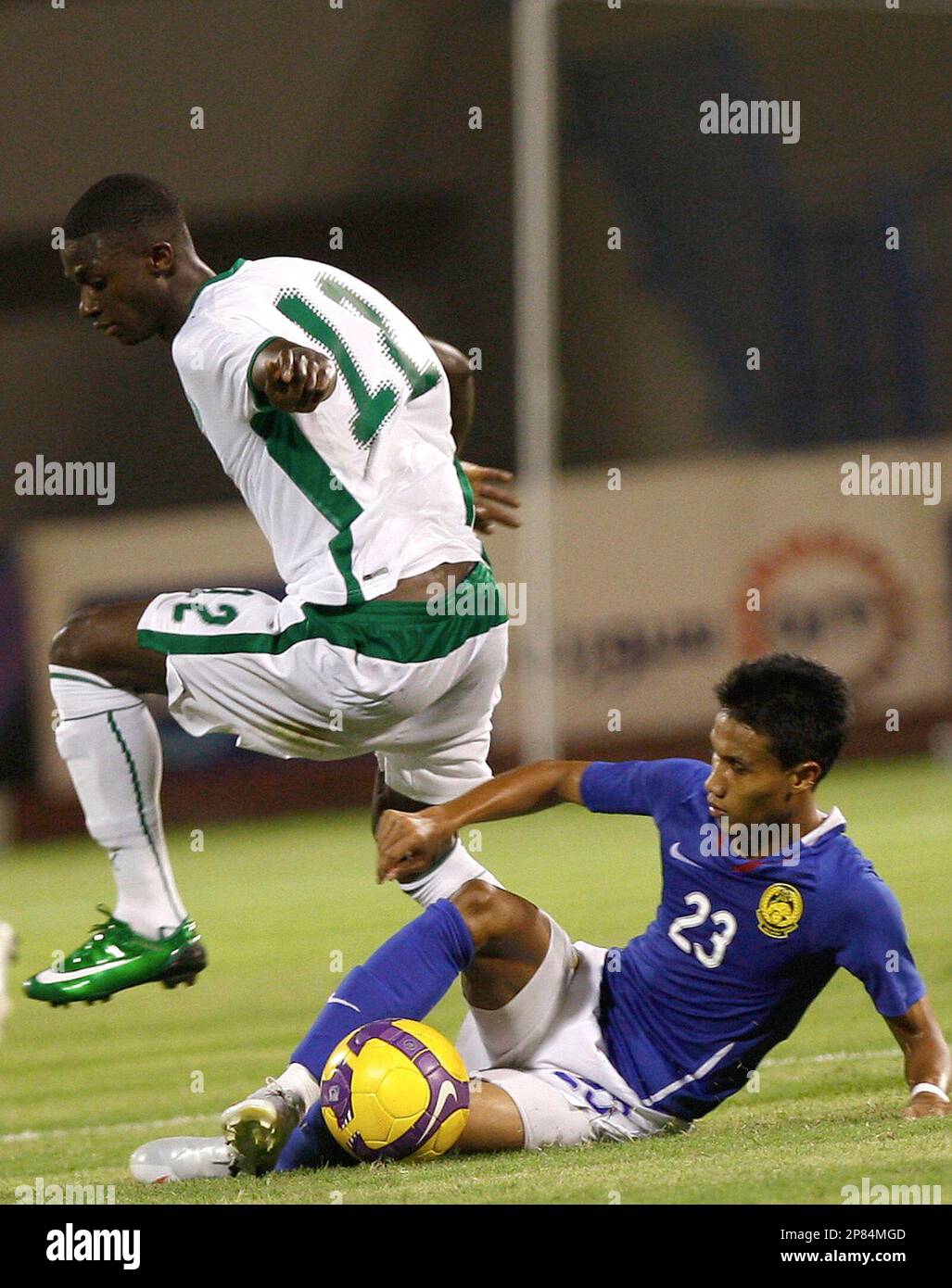 Saudi player Hassan Mouath, left, fights for the ball against Malaysian ...