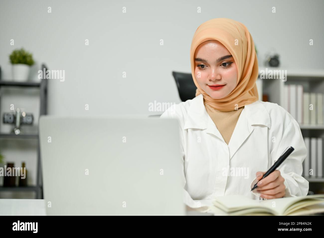 Attractive millennial Asian Muslim businesswoman or female boss wearing ...