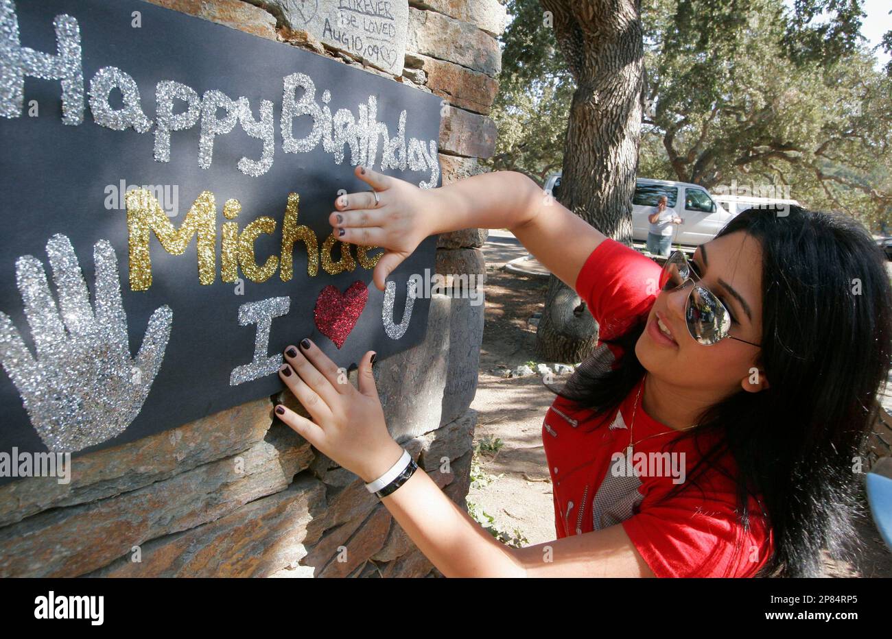 Mariana Eshaya, from San Jose, Calif., hangs a sign on the fence at ...