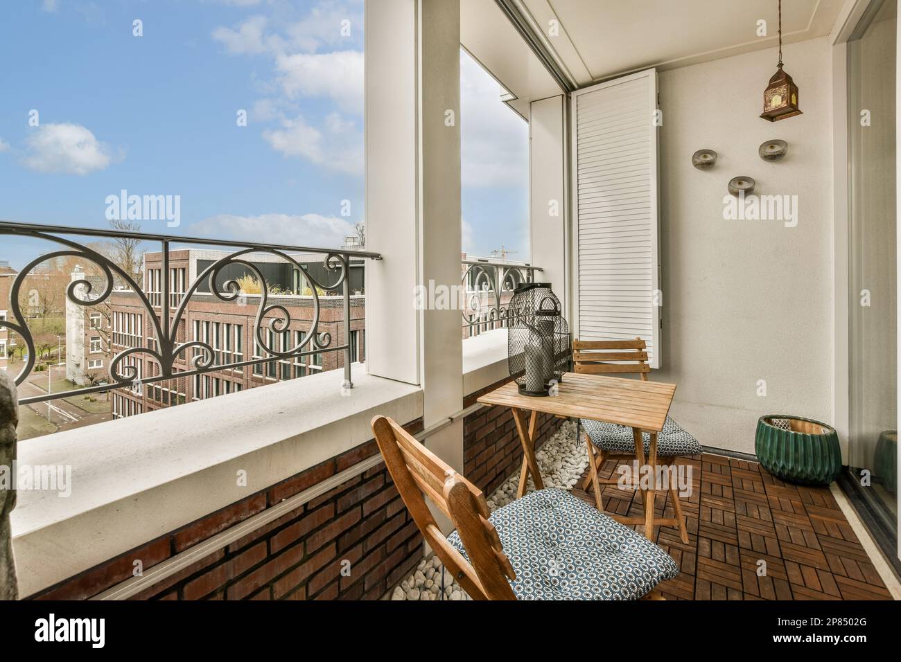 a balcony with some chairs and a table on the left side, looking out to ...