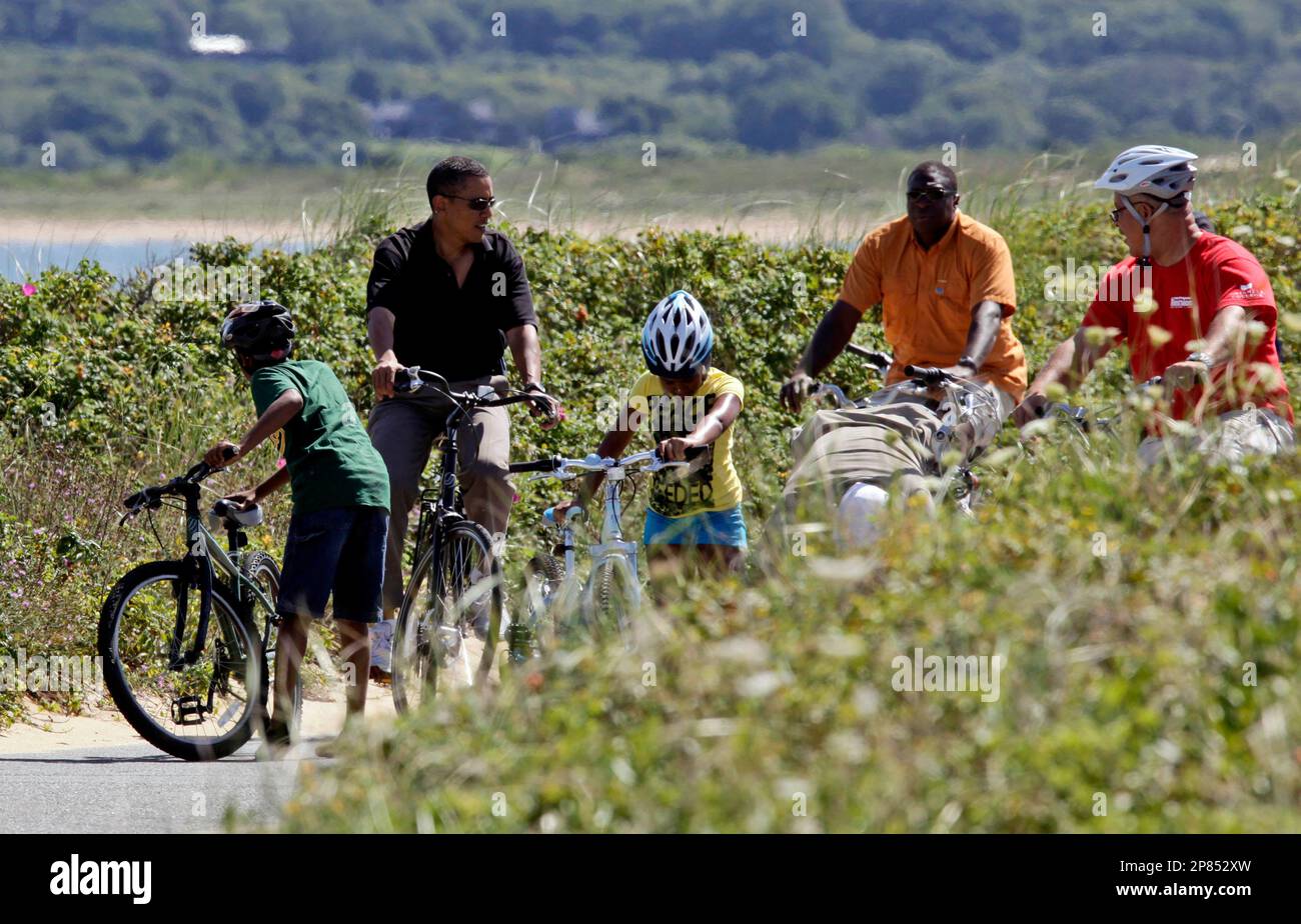 President Barack Obama, second from left, pauses on his bike ride with ...