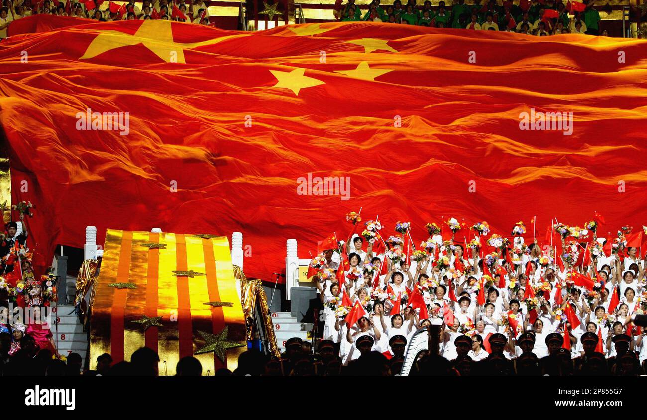 Chinese performers seen near a giant Chinese flag during a chorus ...