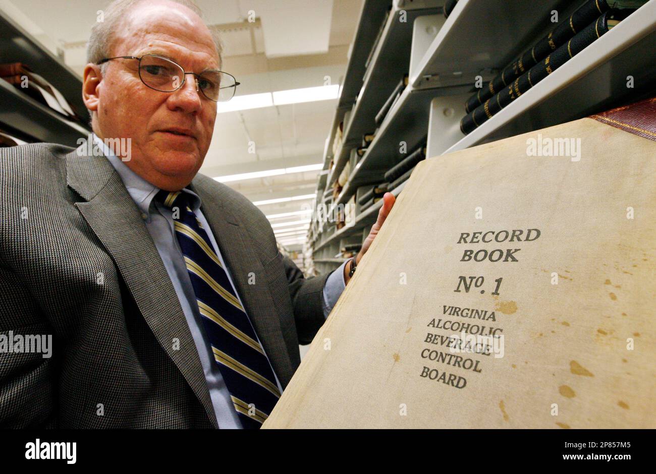 State Archivist Conley Edwards III lholds the first volume of the ...
