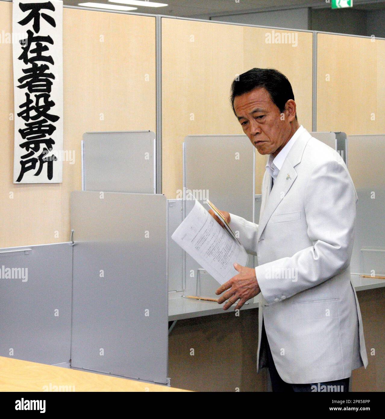 Japan's Prime Minister Taro Aso casts his absentee vote for the Aug. 30 general elections at ...