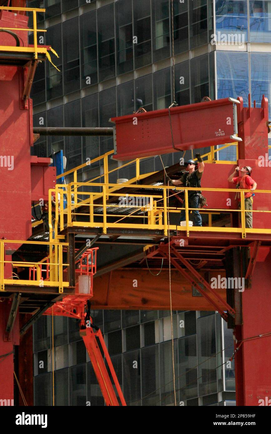 An ironworker guides a steel beam being hoisted by a crane at the ...