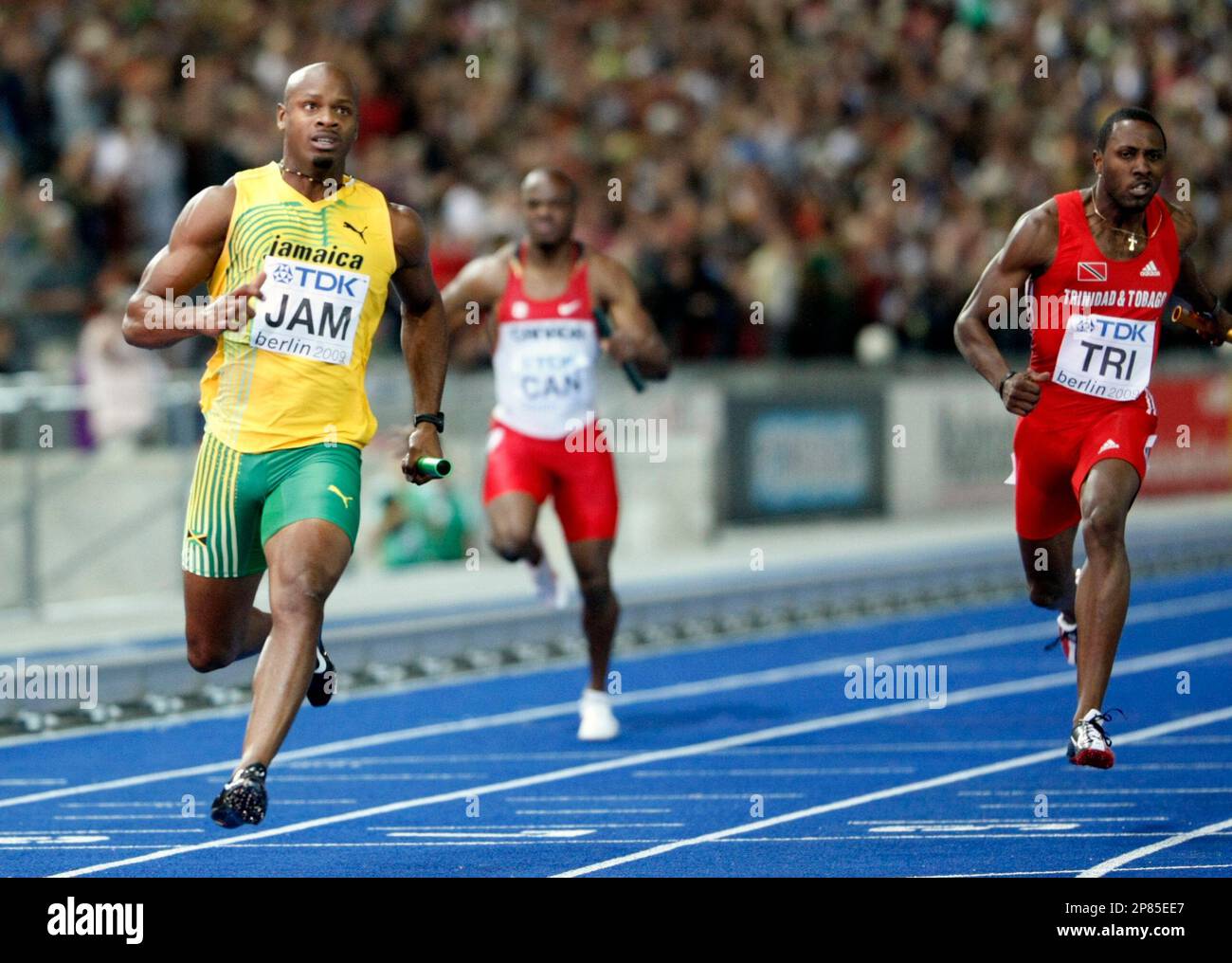 Jamaica's Asafa Powell, left, crosses the finish line to winning gold ...
