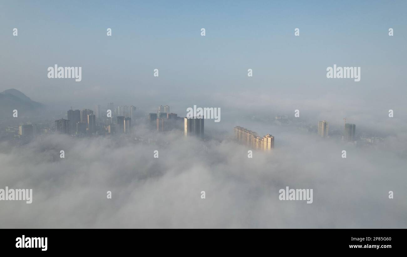 LIUZHOU, CHINA - MARCH 9, 2023 - Buildings are seen surrounded by thick ...