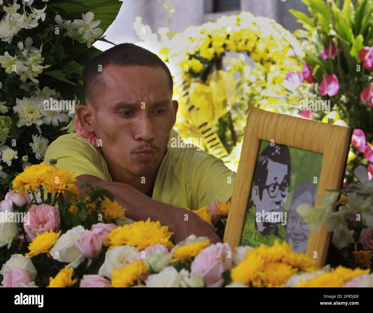 A man places a picture of the late former President Corazon "Cory ...