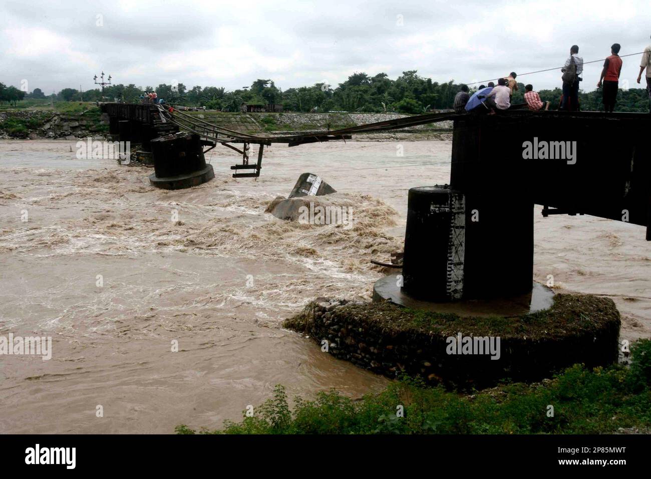 Villagers look at a railway bridge across River Balason that was washed ...