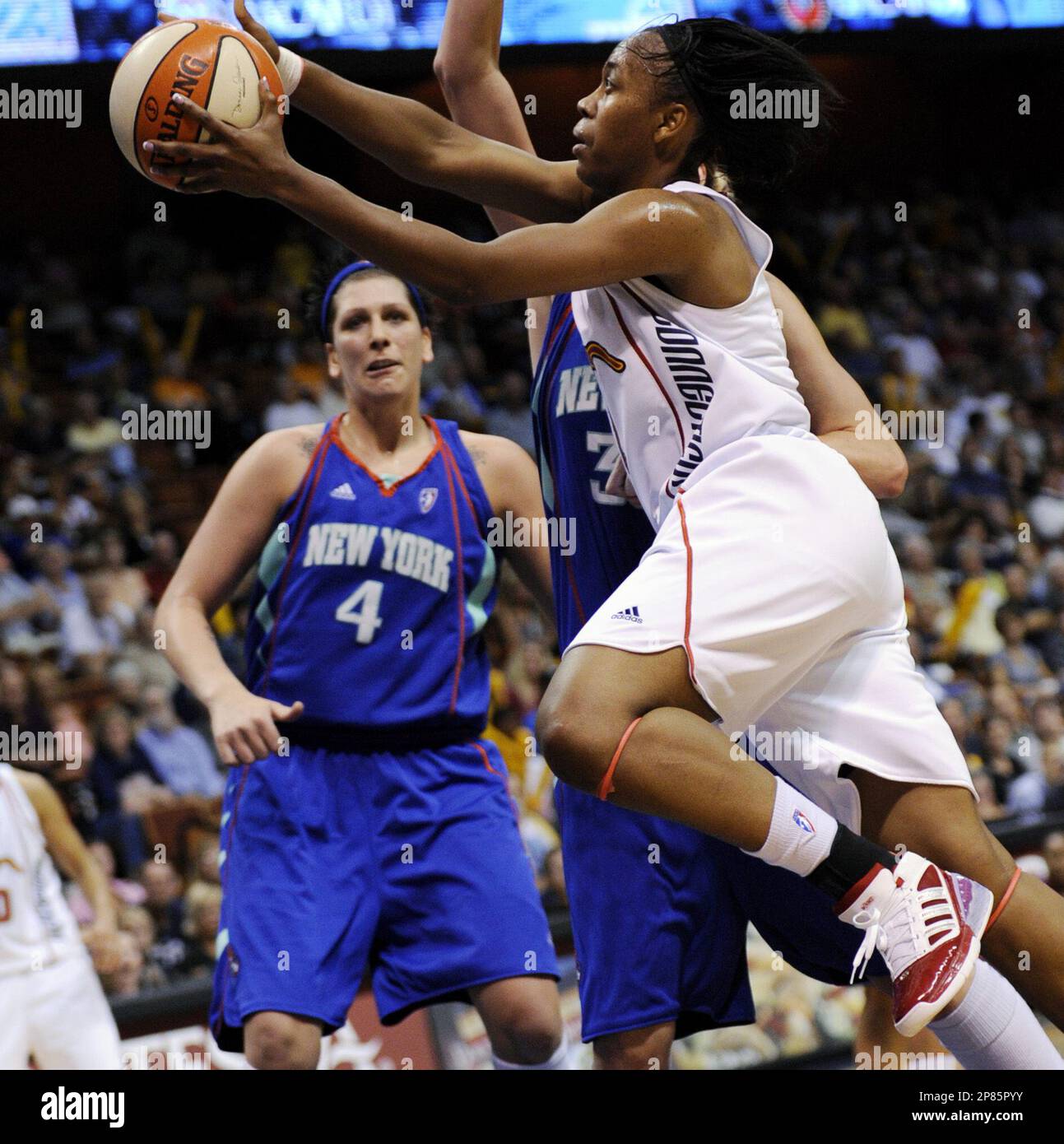 Connecticut Sun's Amber Holt goes up past the Liberty's Janel ...