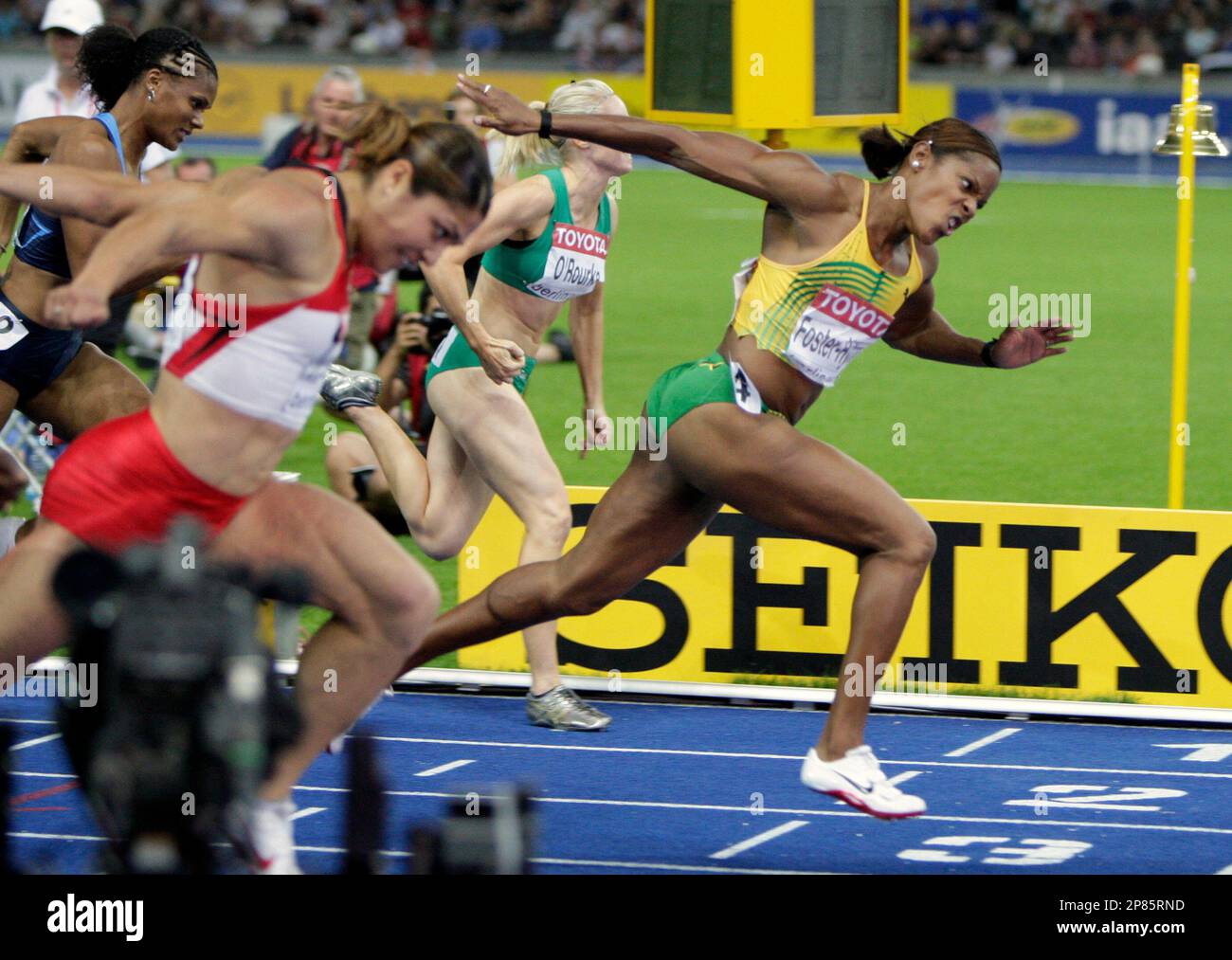 Jamaica's Brigitte Foster-Hylton, right, crosses the finish line to win ...