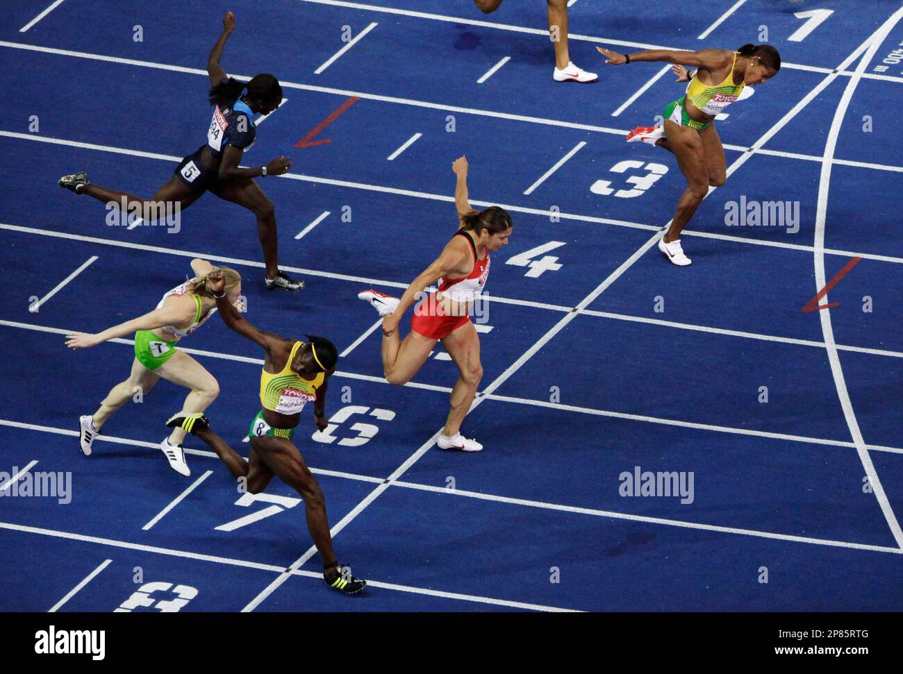 Jamaica's Brigitte Foster-Hylton, right, crosses the finish line to win ...