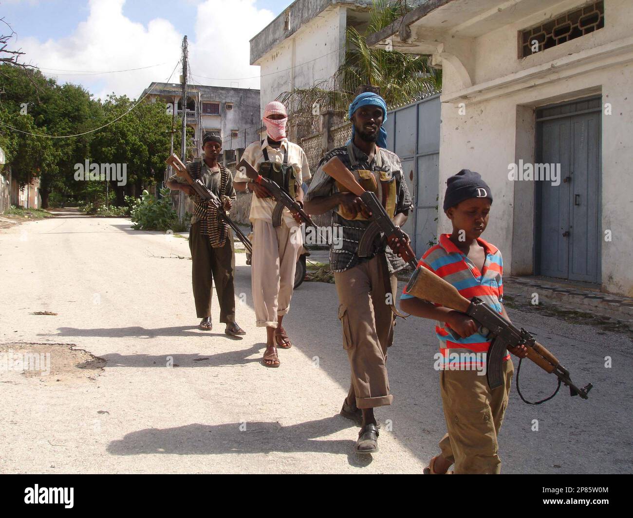 A young member of an Islamic militia group leads the way with other ...