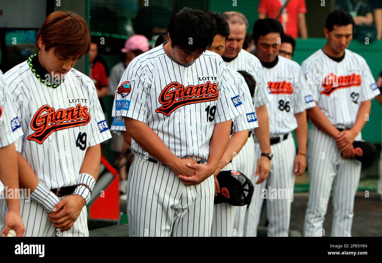 South Korean pro baseball Lotte Giants players pray in a moment of ...
