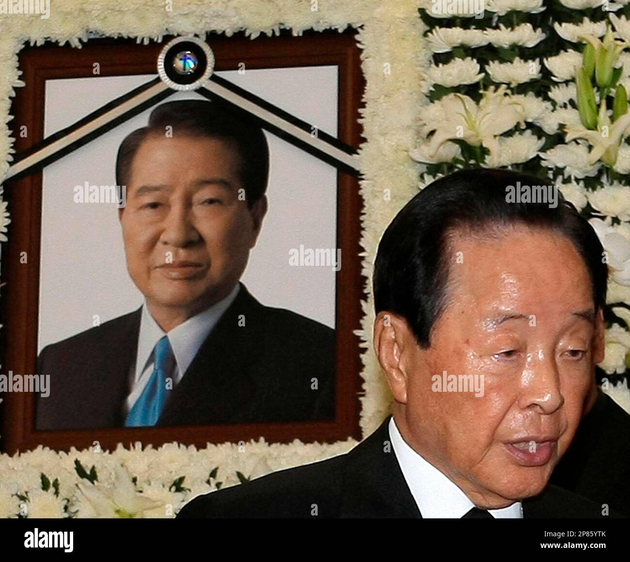 South Korea's former President Kim Yong-sam walks past a portrait of ...