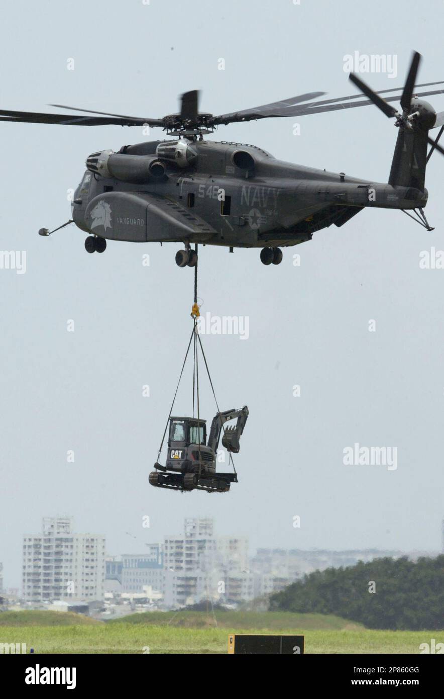 A U.S. CH-53 helicopter lifts a front hoe at the Tainan air force base ...