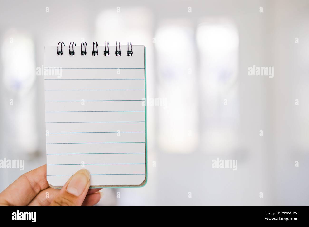 hand holding small notepad with blank copy space in front of stylish ...