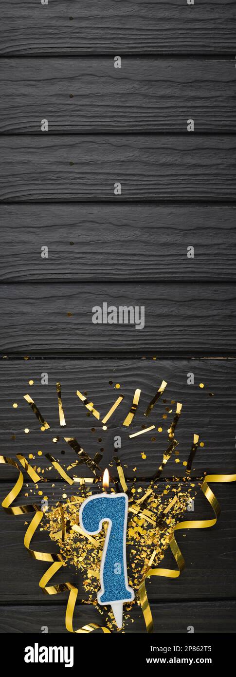 Number 7 blue celebration candle and gold confetti on dark wooden ...