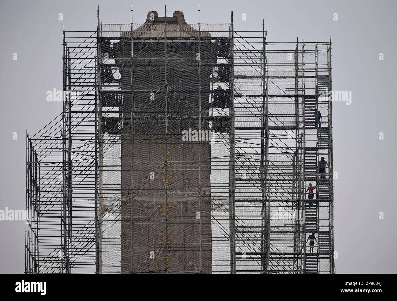 Workers are seen on scaffolding built around the Monument to the People ...