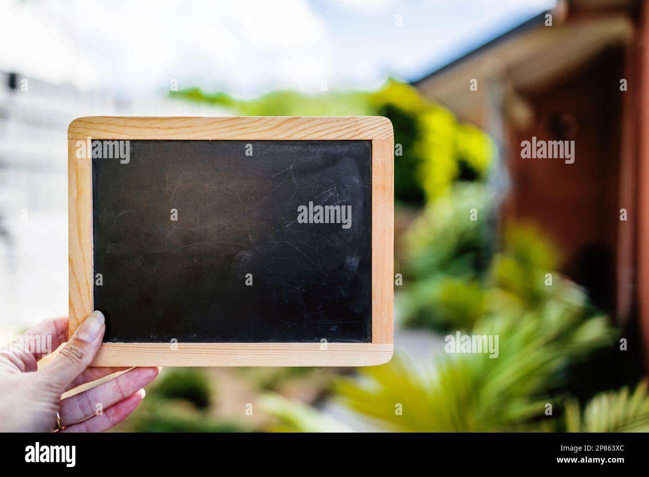 hand holding small blackboard with blank copy space in front of stylish ...