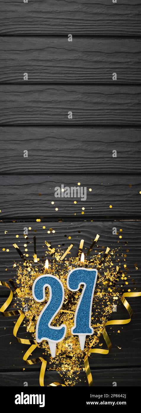 Number 27 blue celebration candle and gold confetti on dark wooden ...