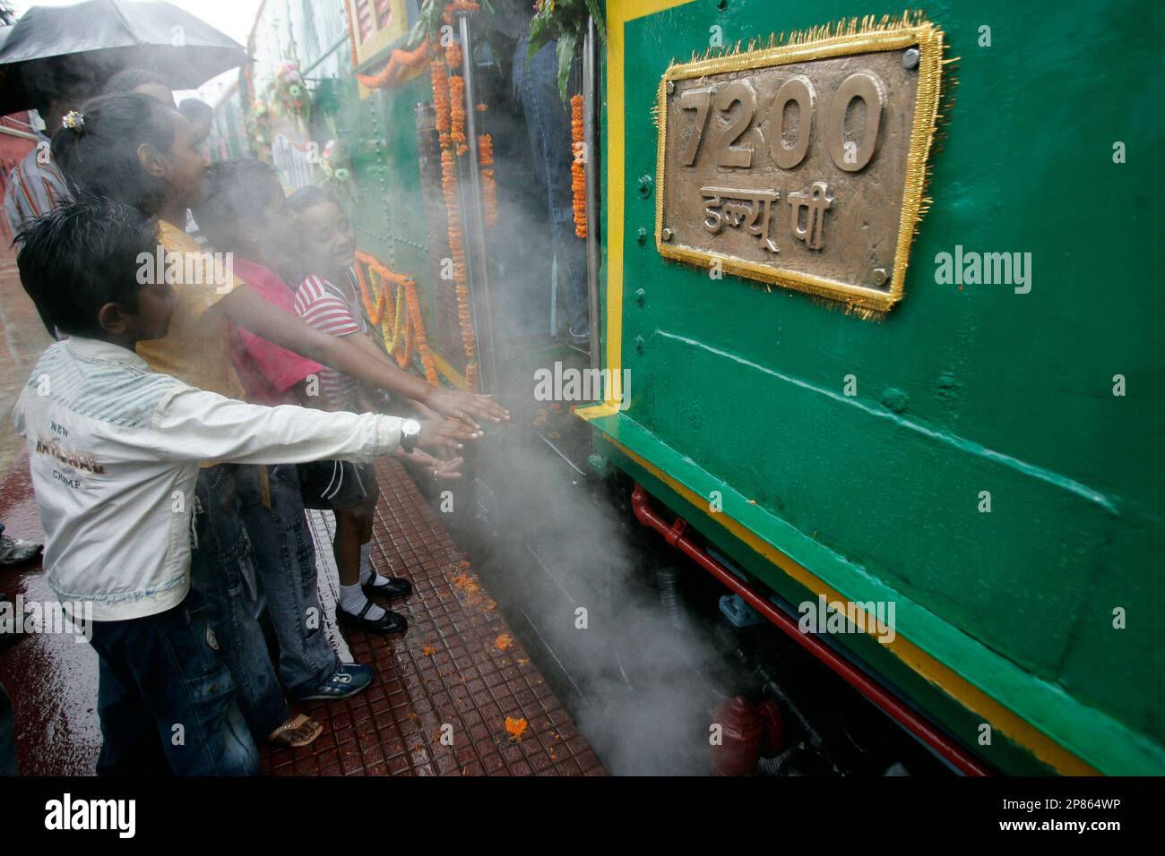 Children feel the steam from a steam locomotive engine during the re ...
