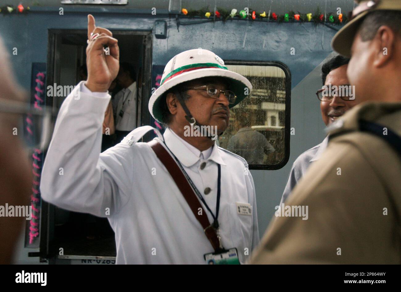 A railway guard in Colonial costume talks with a police officer during ...