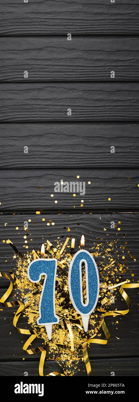 Number 70 Blue Celebration Candle And Gold Confetti On Dark Wooden