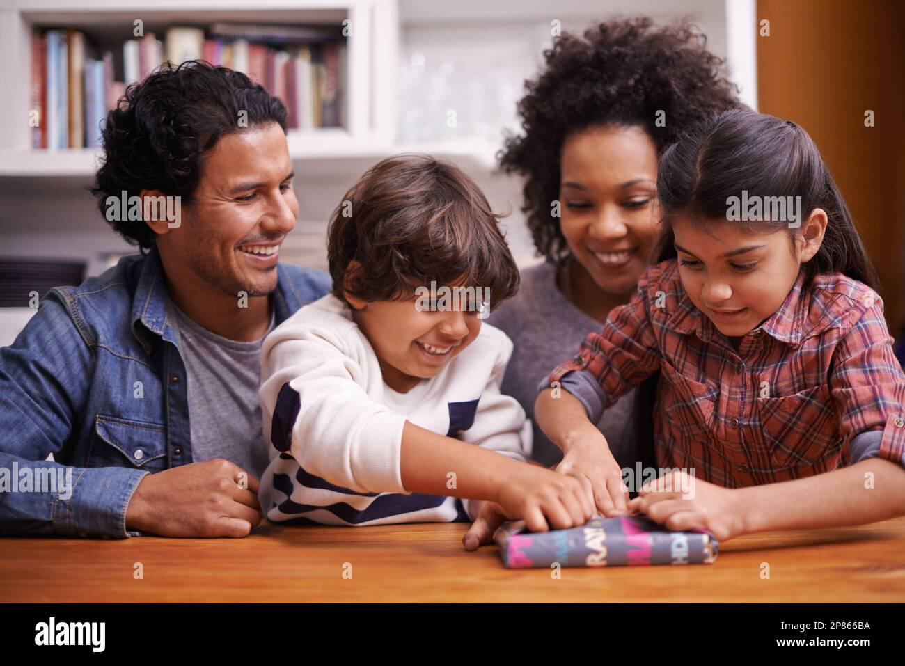 Spending quality time together. two siblings opening a present while ...