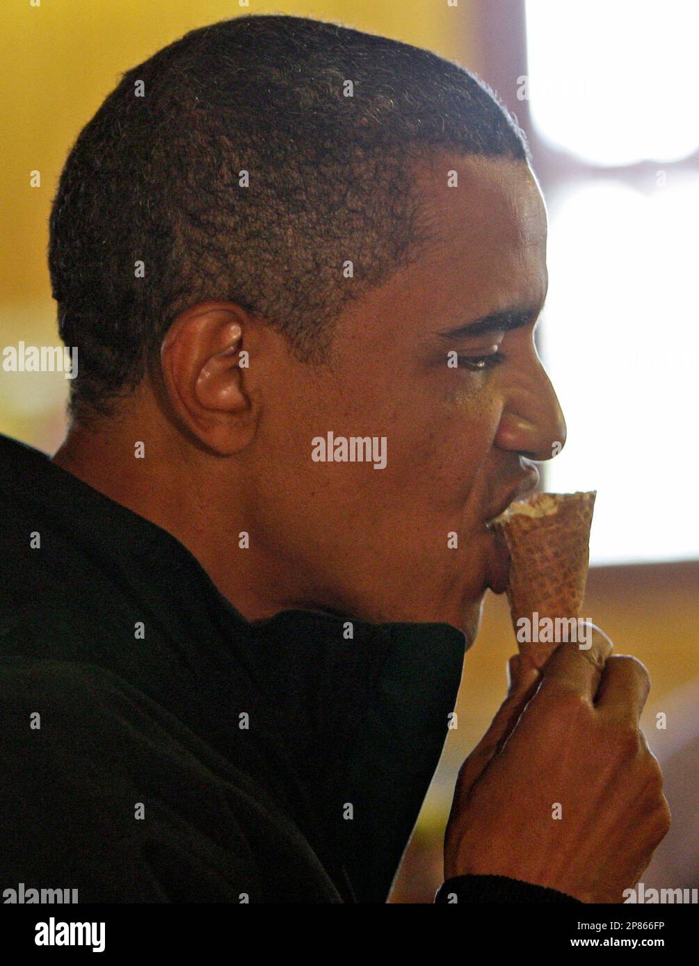 President Barack Obama takes a bite of an ice cream cone at the Old ...